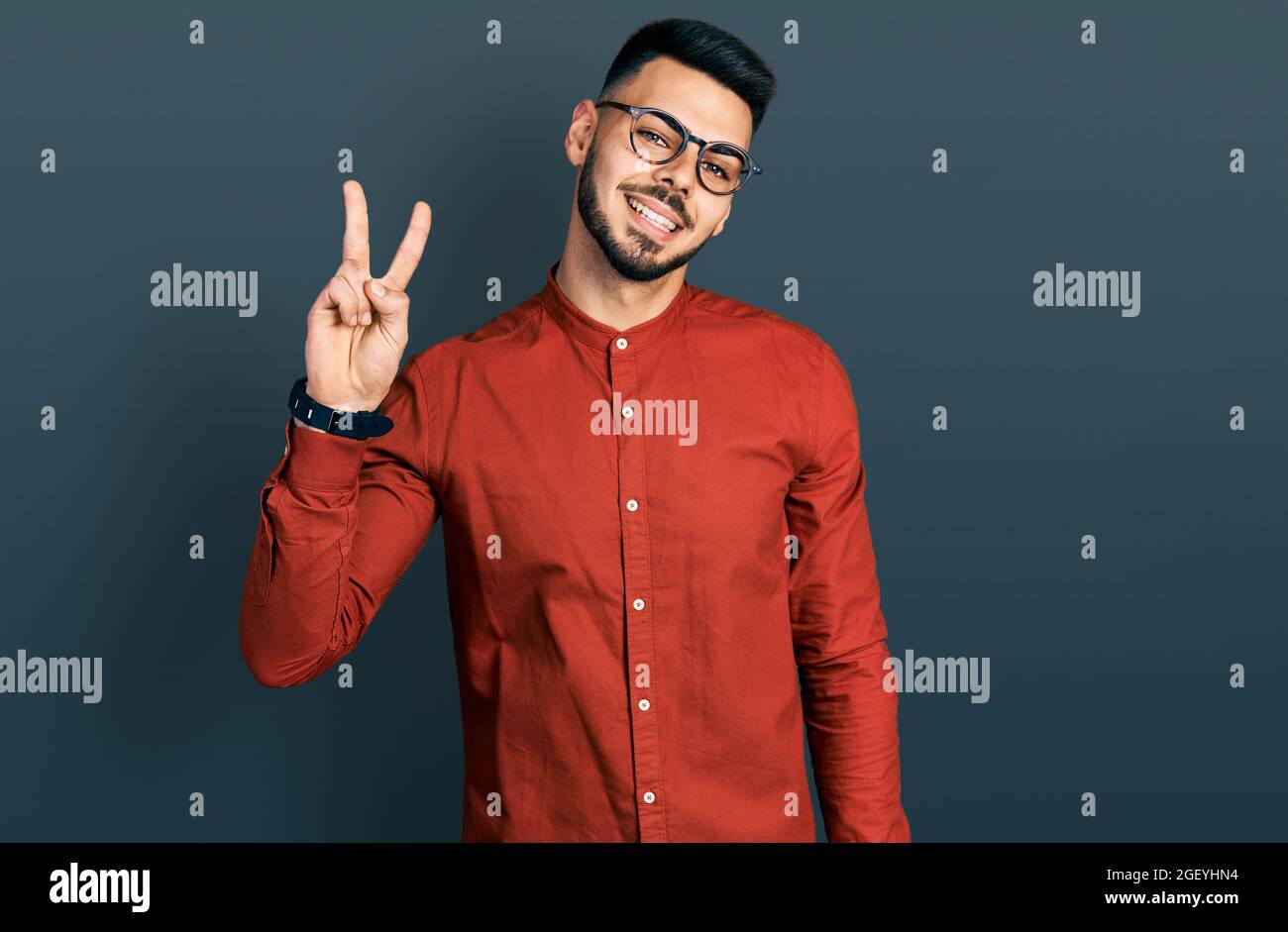 Young hispanic man with beard wearing business shirt and glasses ...