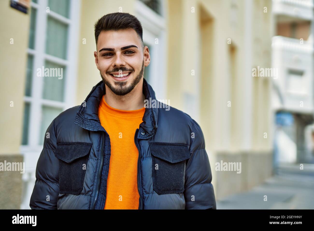 Handsome hispanic man with beard smiling happy and confident at the ...