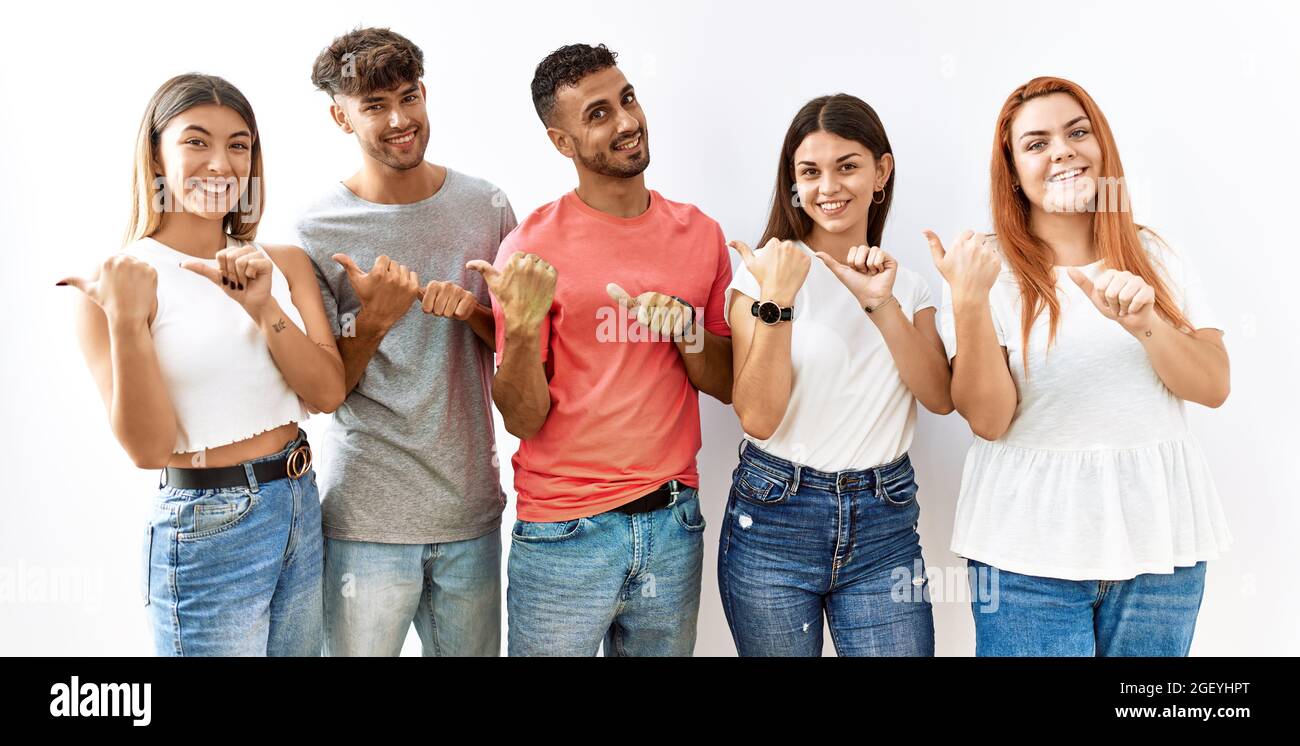 Group of young friends standing together over isolated background ...