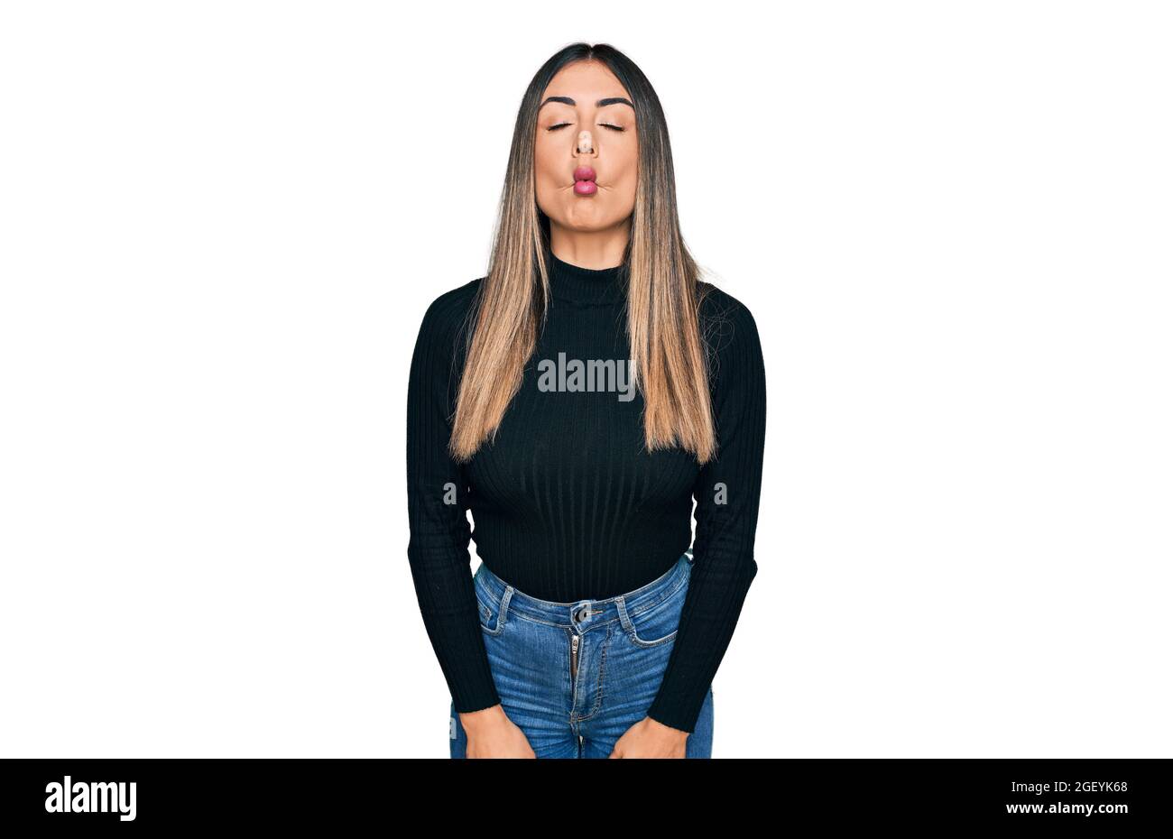 Young hispanic woman wearing casual clothes making fish face with lips ...