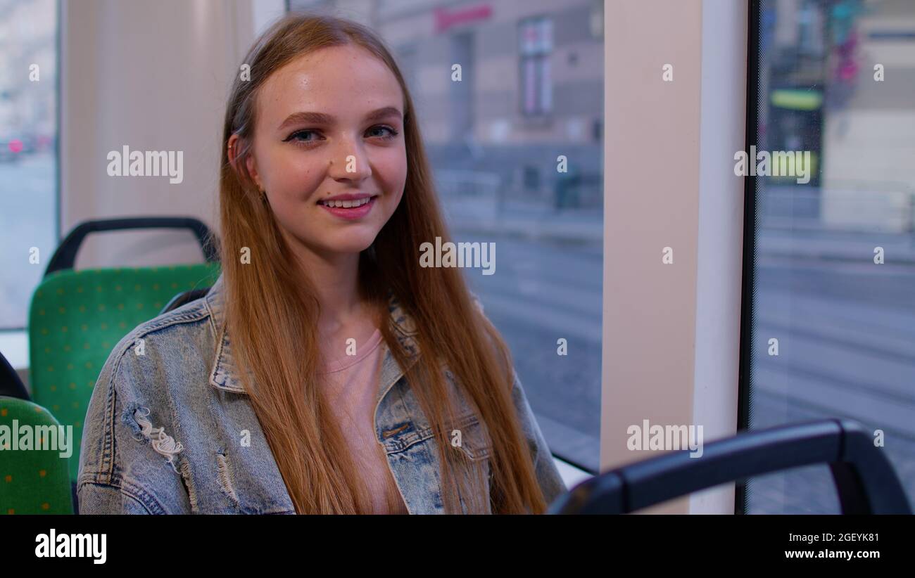 Attractive young woman passenger riding at public modern bus or tram ...
