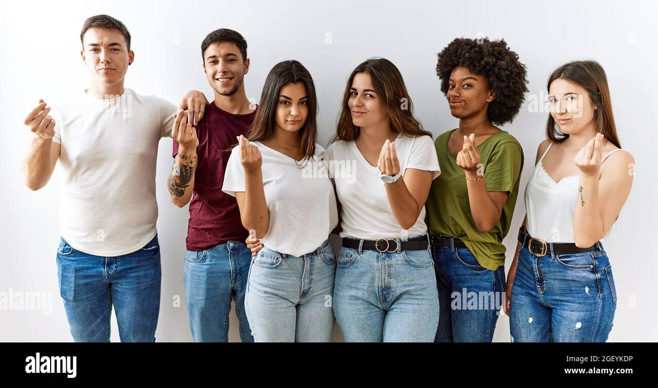 Group of young friends standing together over isolated background doing ...