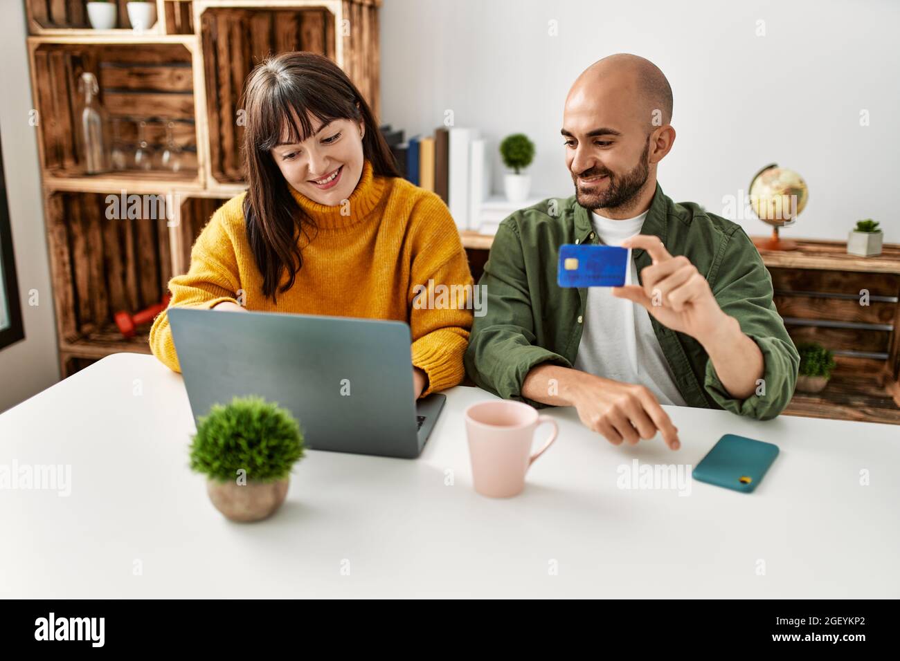 Young hispanic couple smiling happy using laptop and credit card ...