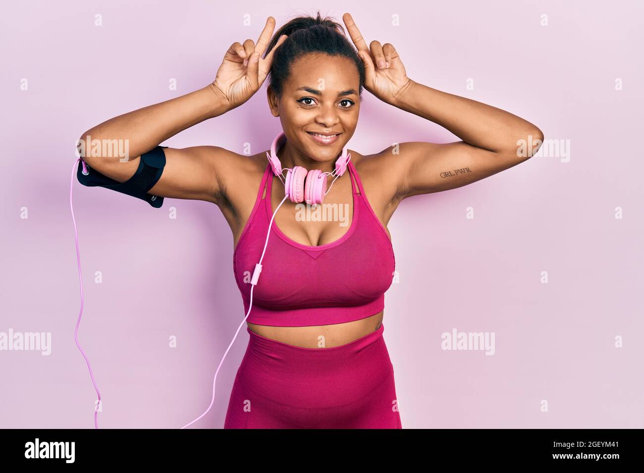 Young african american girl wearing gym clothes and using headphones ...