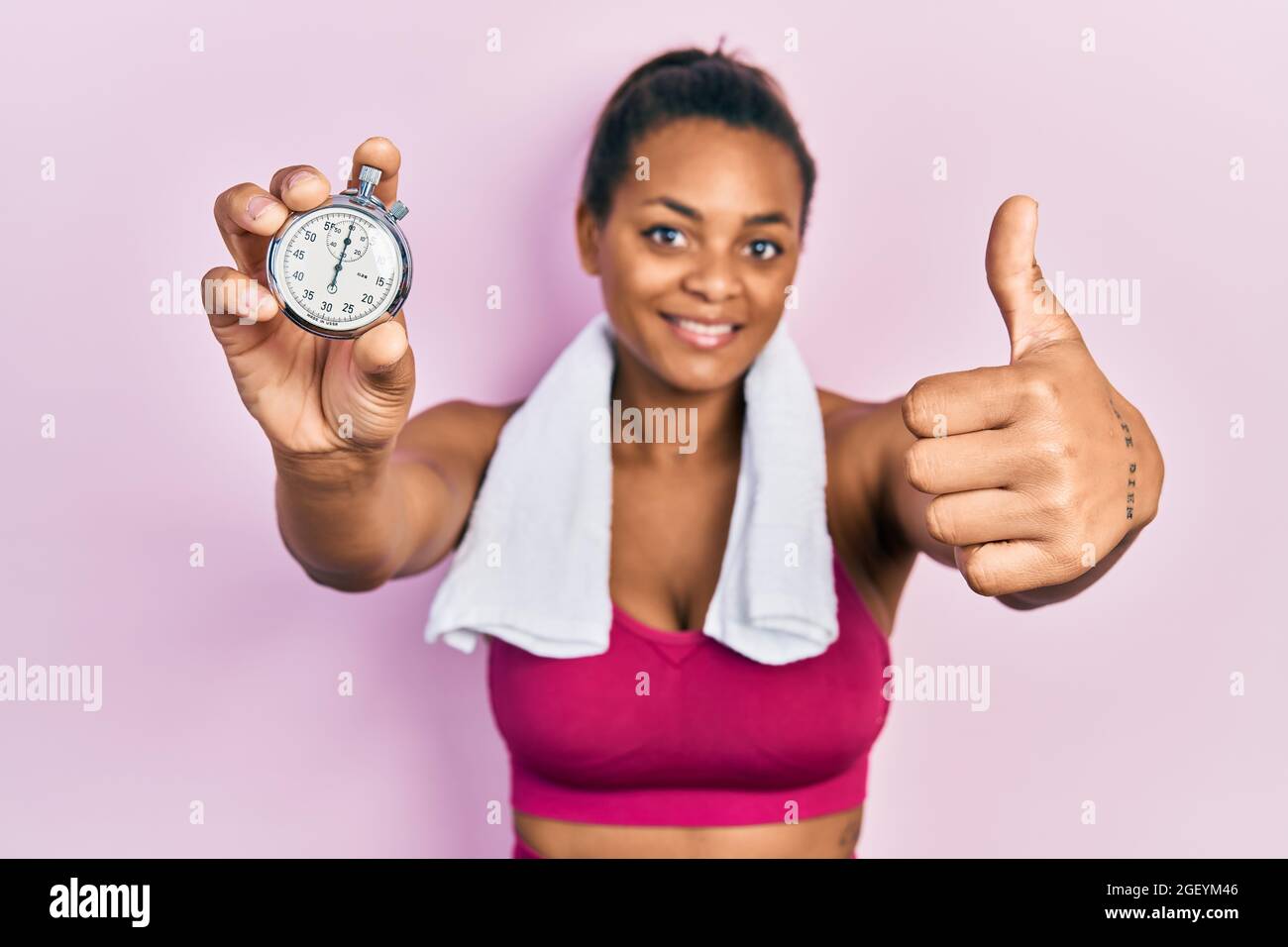 Young african american girl wearing sportswear holding stopwatch ...