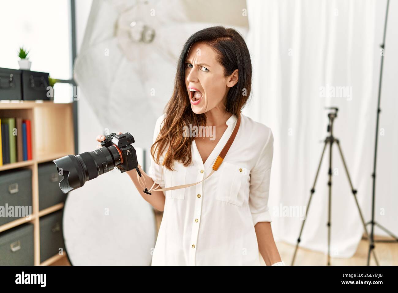 Beautiful caucasian woman working as photographer at photography studio ...