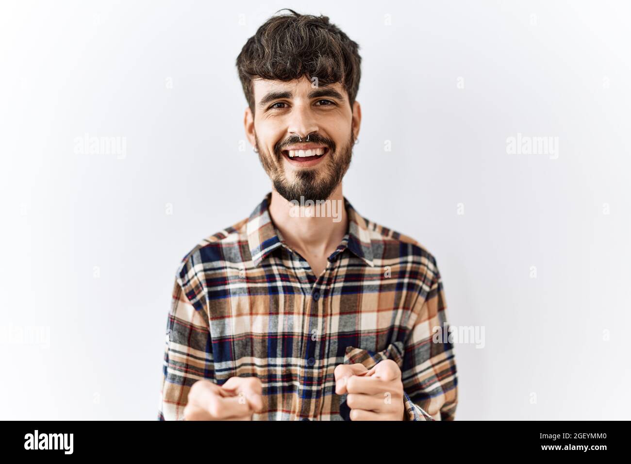 Hispanic man with beard standing over isolated background pointing ...
