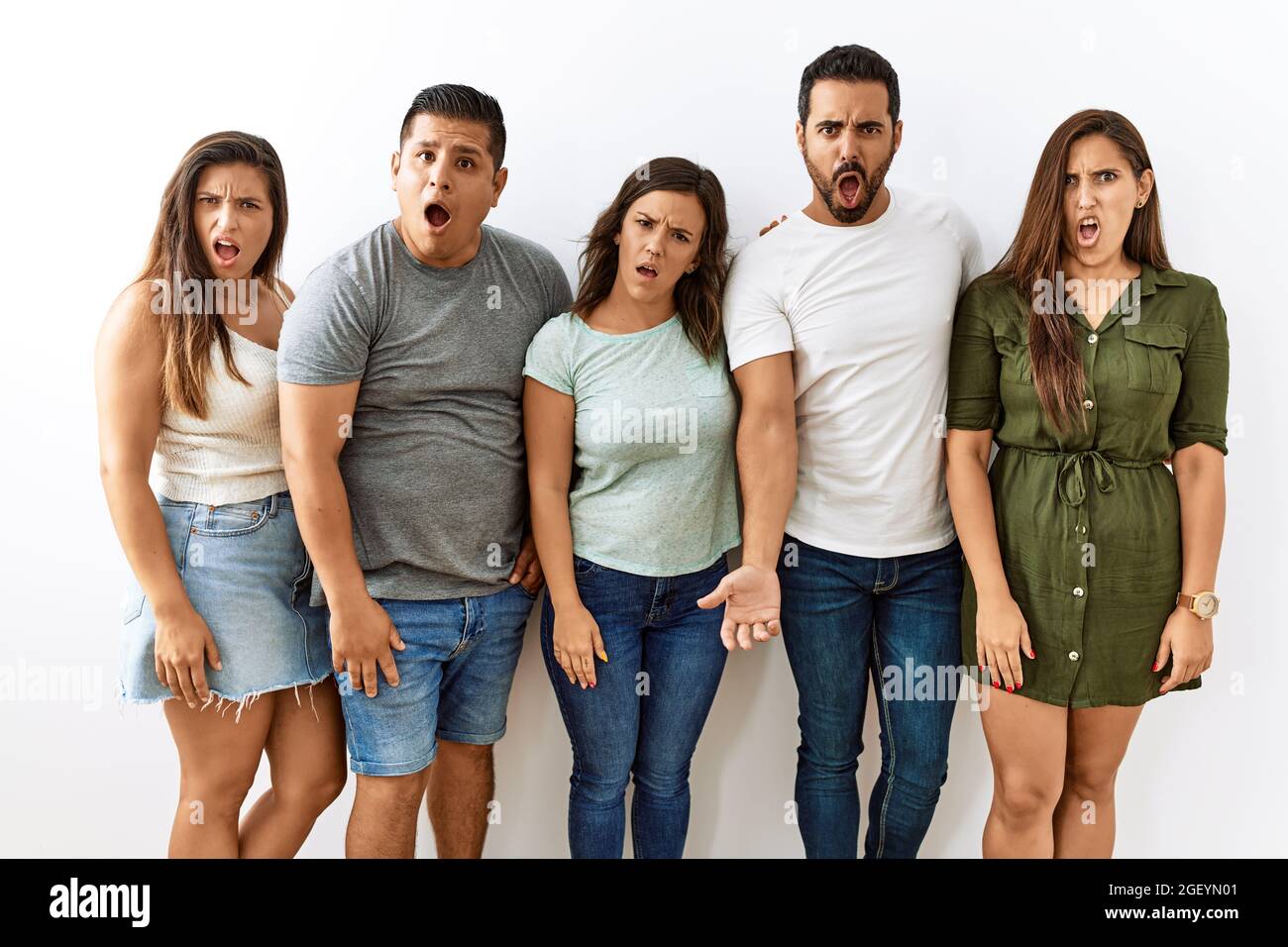 Group of young hispanic friends standing together over isolated ...