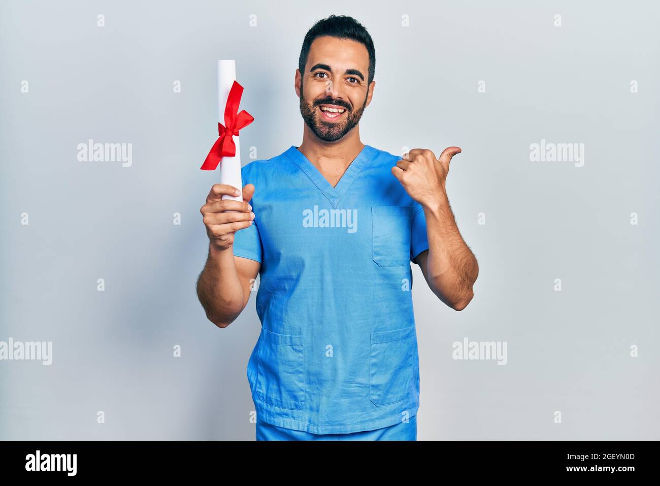 Handsome hispanic man with beard wearing blue male nurse uniform ...