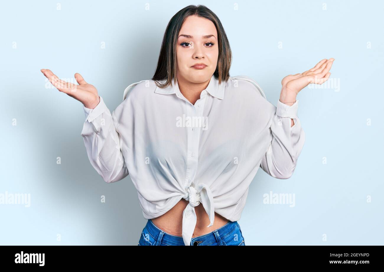 Young hispanic woman wearing casual clothes clueless and confused with ...