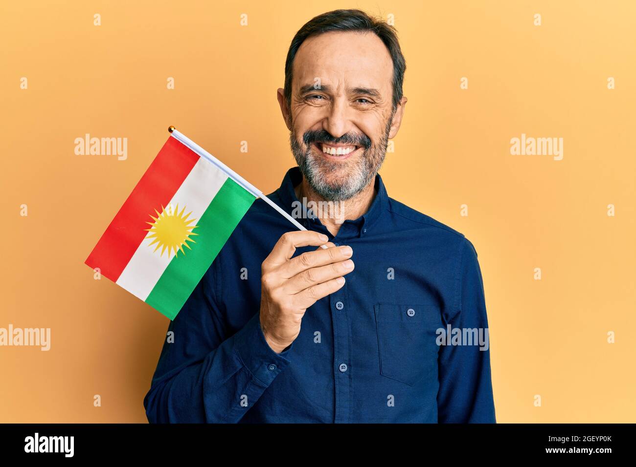 Middle age hispanic man holding pakistan flag looking positive and ...