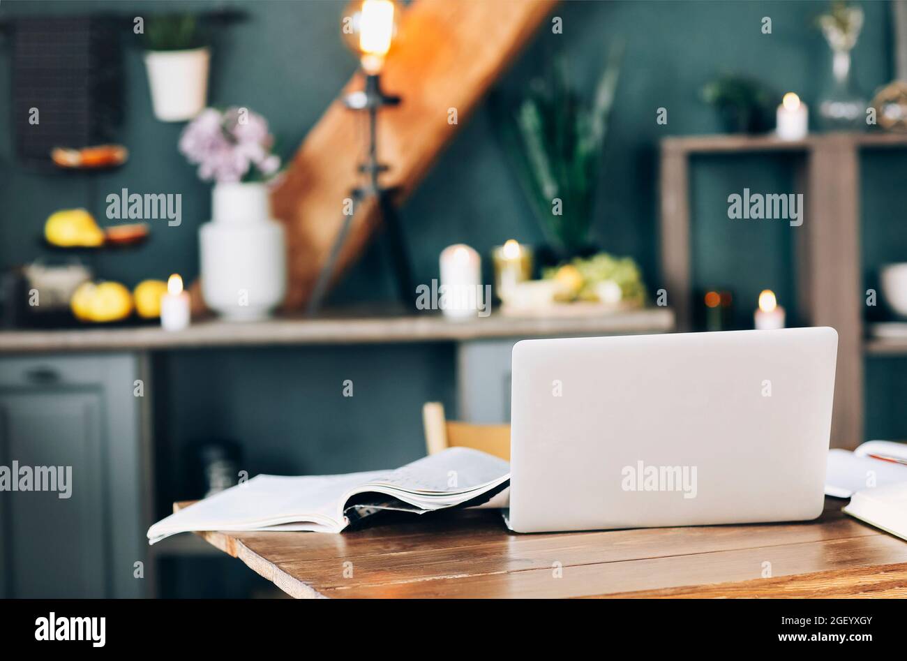 Open textbook with pen, laptop, stack of uncovered books lying on each ...