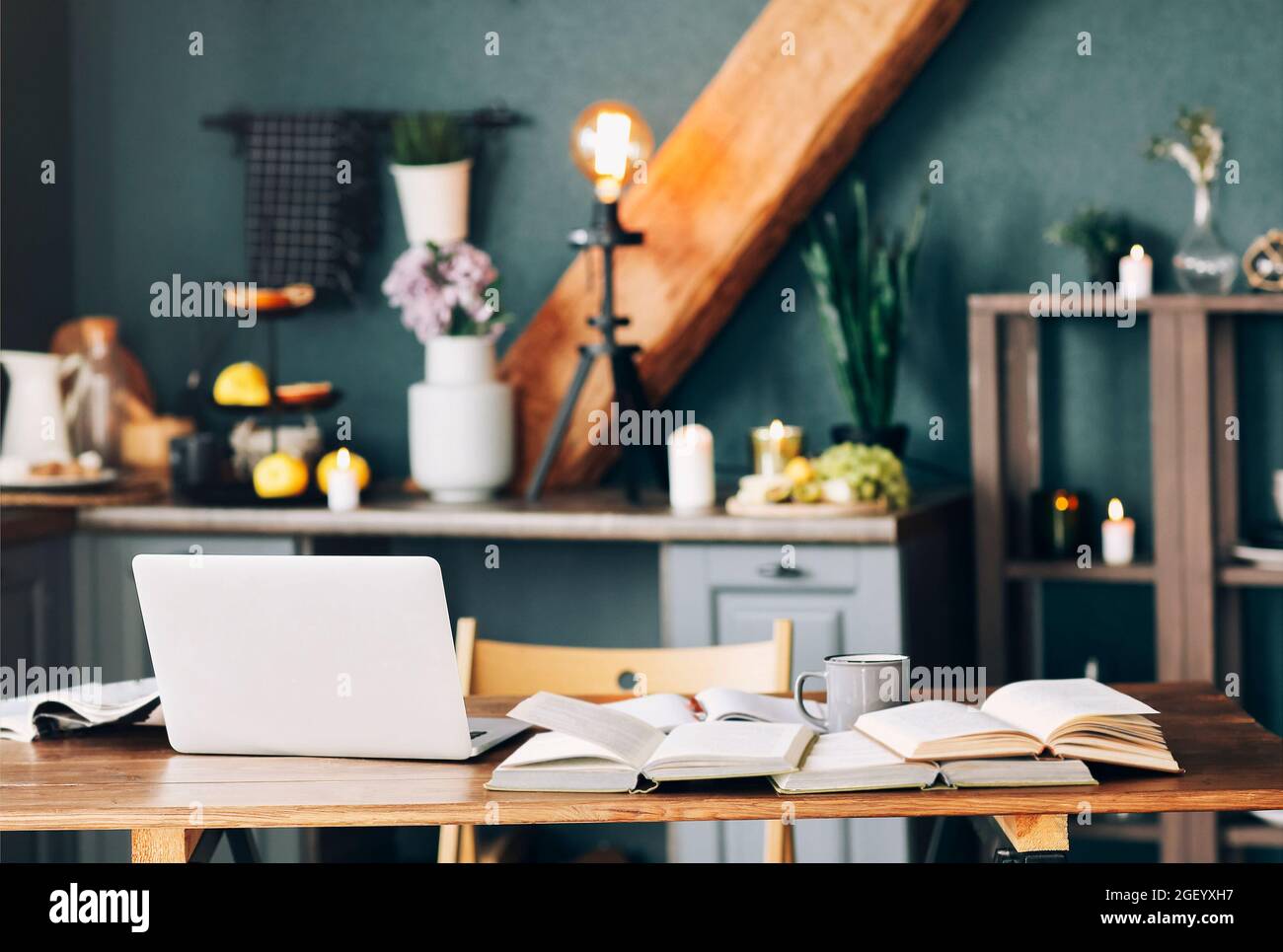 Open textbook with pen, laptop, stack of uncovered books lying on each ...