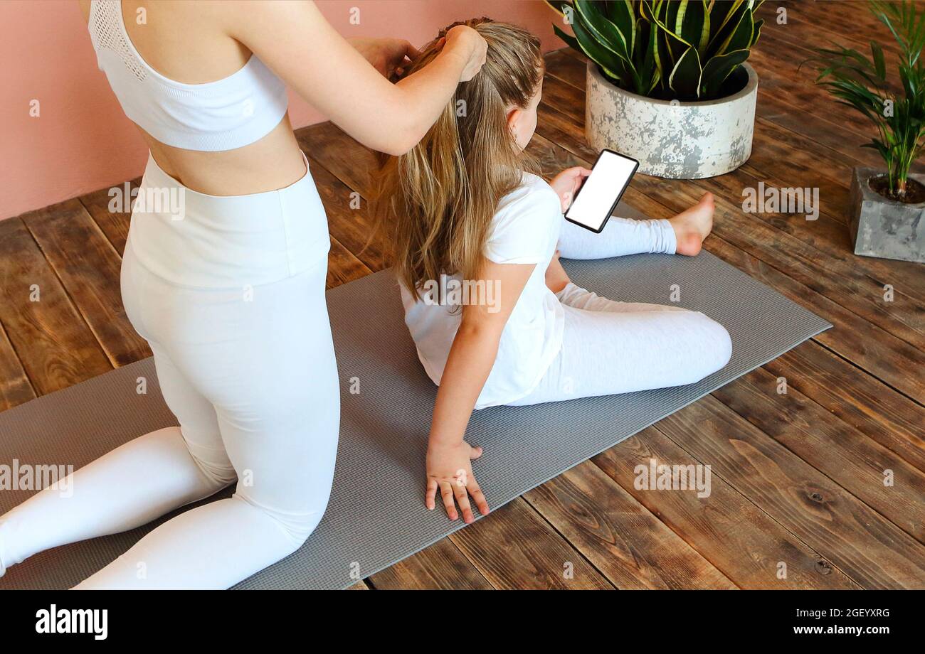 Young Blonde Girl Getting Her Long Hair Braided By Woman Hairdresser