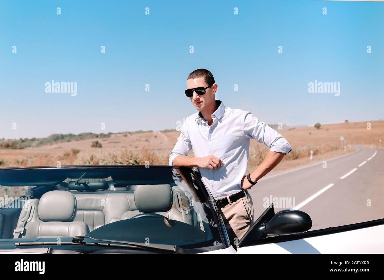 Handsome young man in black sunglasses leaning on luxury white ...