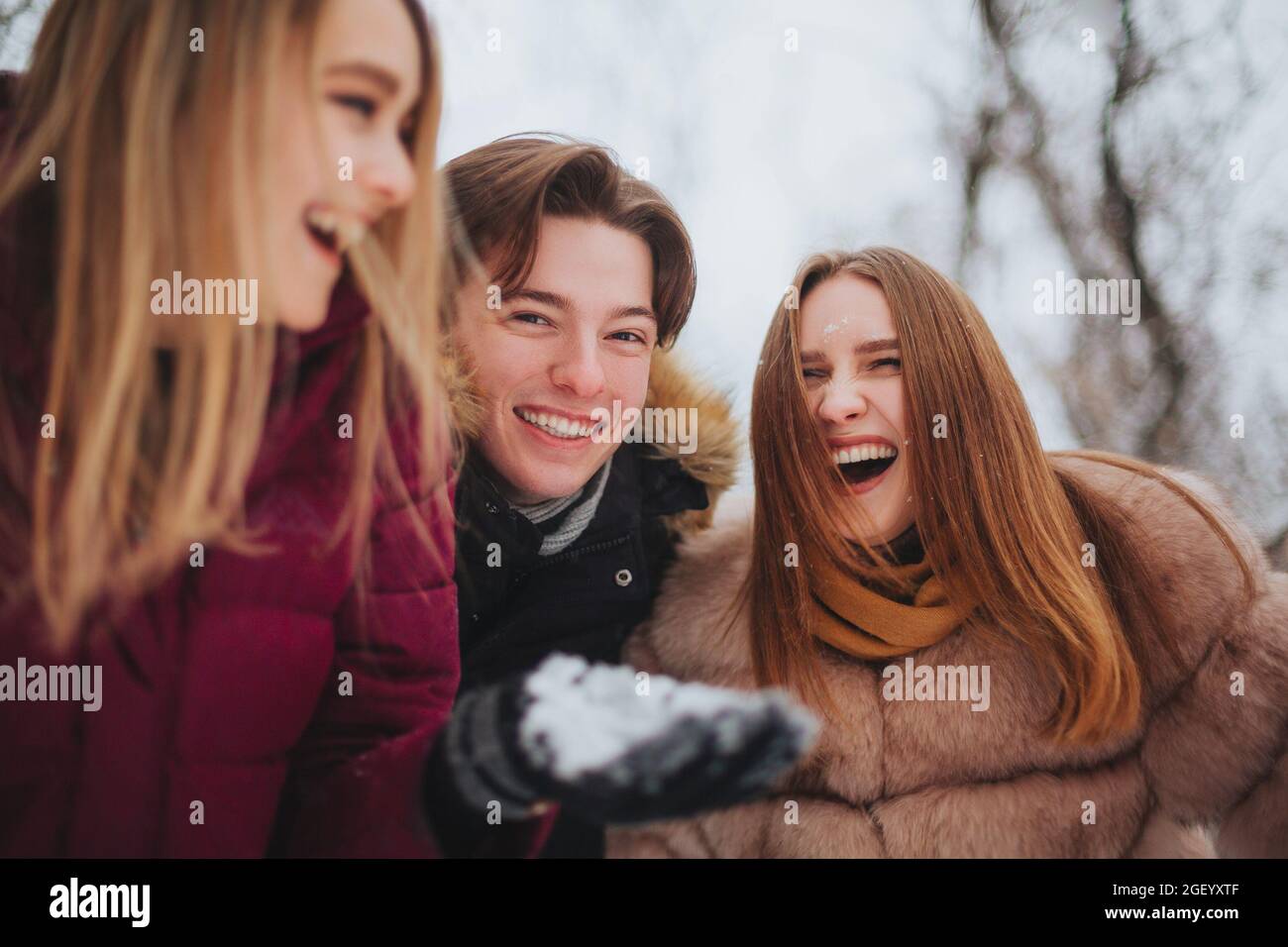 Group of four joyful best friends enjoying cold weather and first snow ...