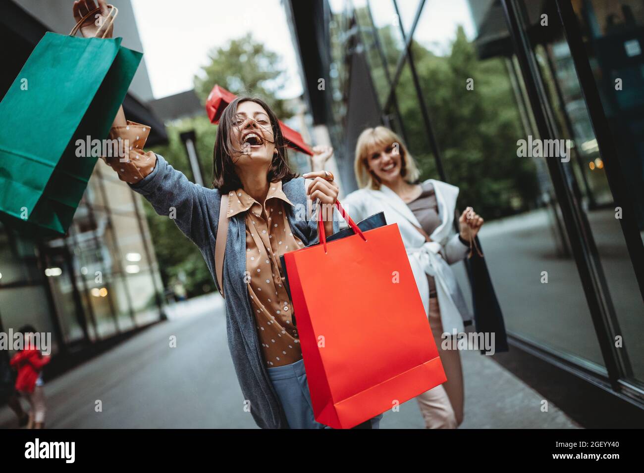 Beautiful happy women with shopping bags walking and having fun Stock ...