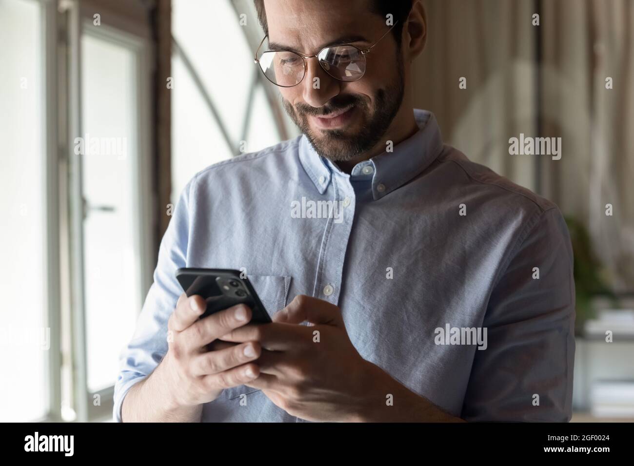 Happy man employee use smartphone browsing internet Stock Photo - Alamy