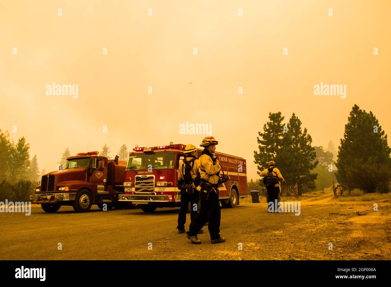 Firefighters monitor a residential area in heavy smoke. The Dixie fire ...