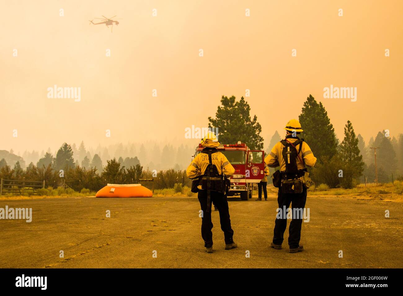 Firefighters watch airdrops on the Dixie fire. The Dixie fire continues ...