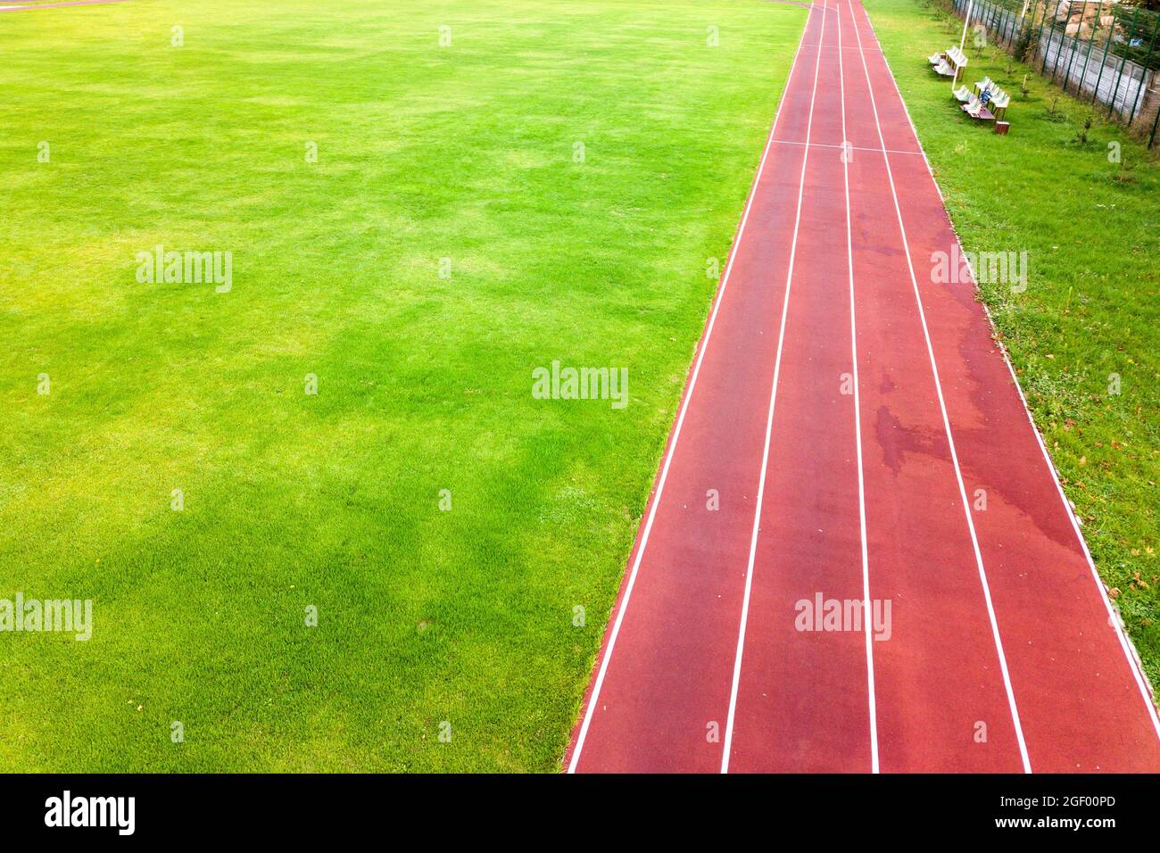 Aerial view of sports stadium with red running tracks and green grass ...