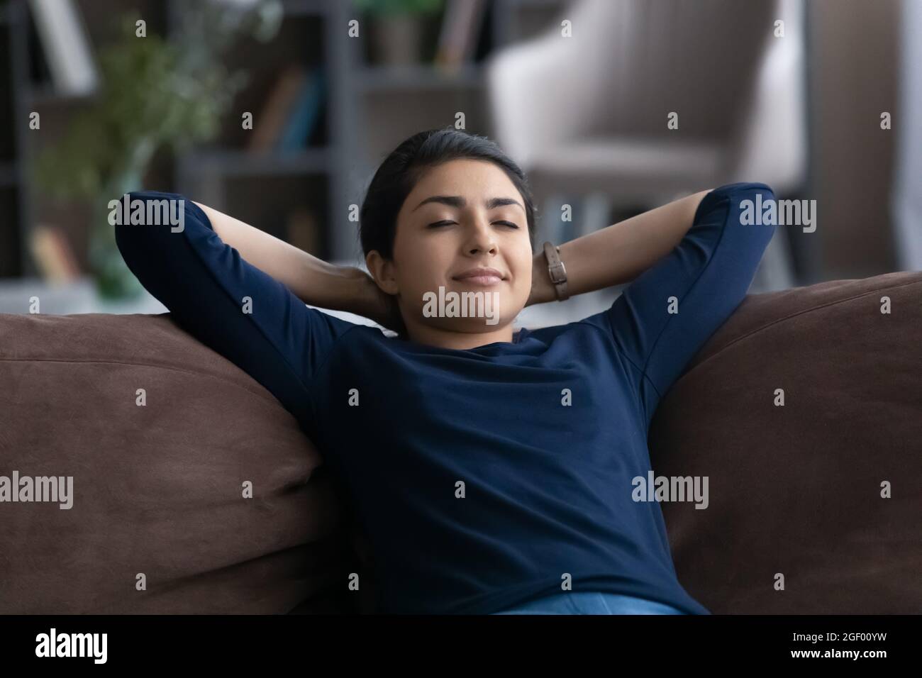 Young Indian woman take nap on comfortable couch Stock Photo - Alamy