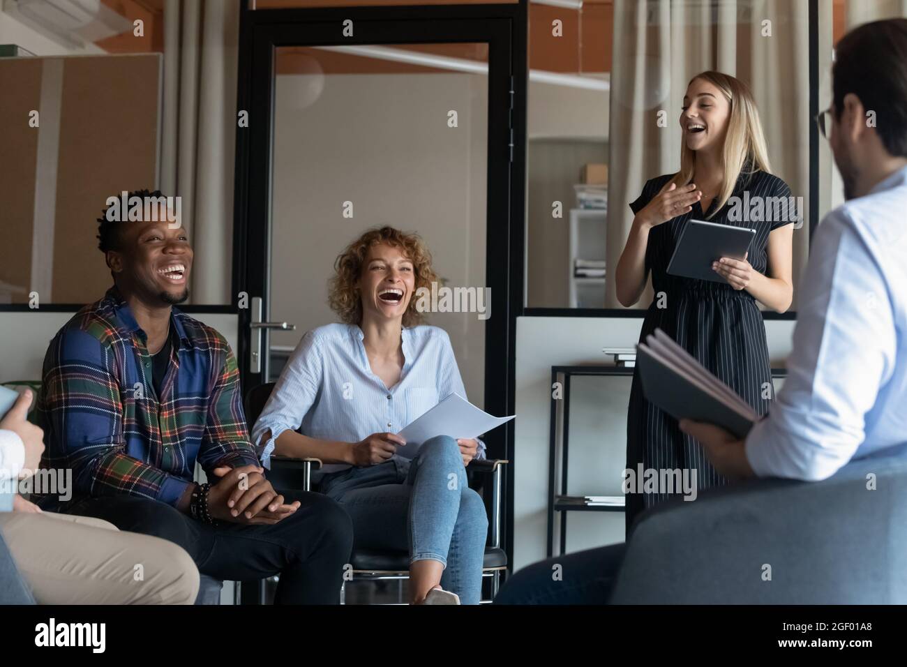 Smiling multiethnic colleagues laugh talking at meeting Stock Photo - Alamy