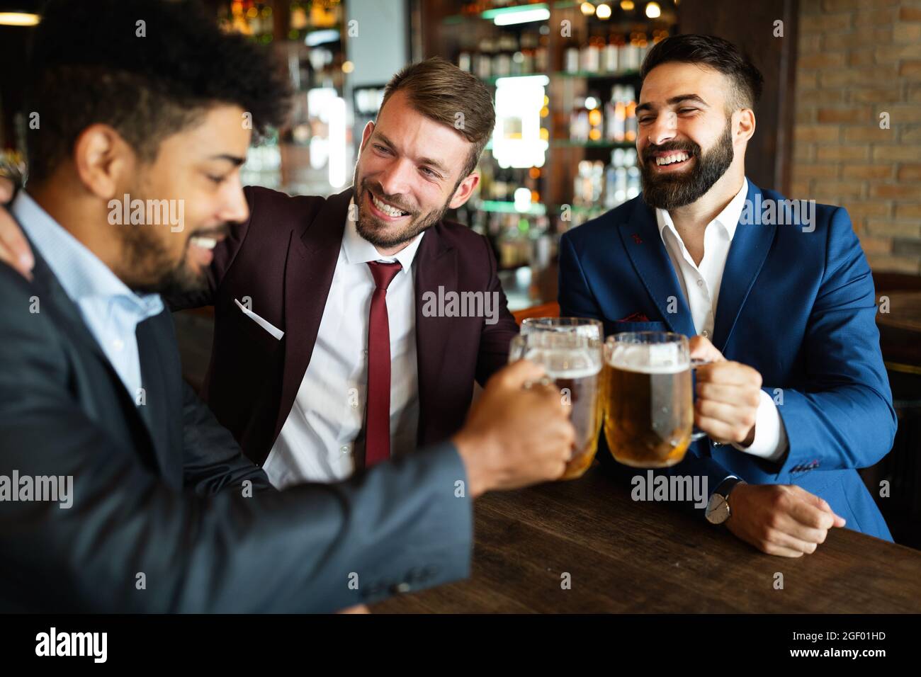 Team of colleagues socializing at the bar and drinking beers Stock ...