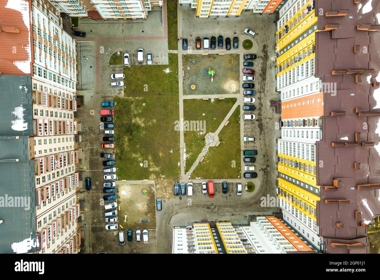 Aerial view of parked cars on parking lot between high apartment ...