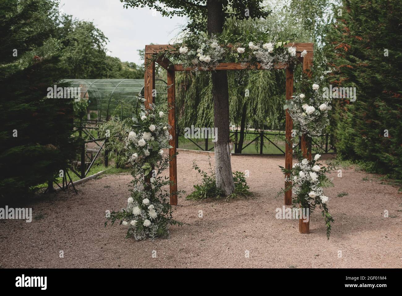 Rustic wedding arch for an ceremony decorated with white and flowers ...