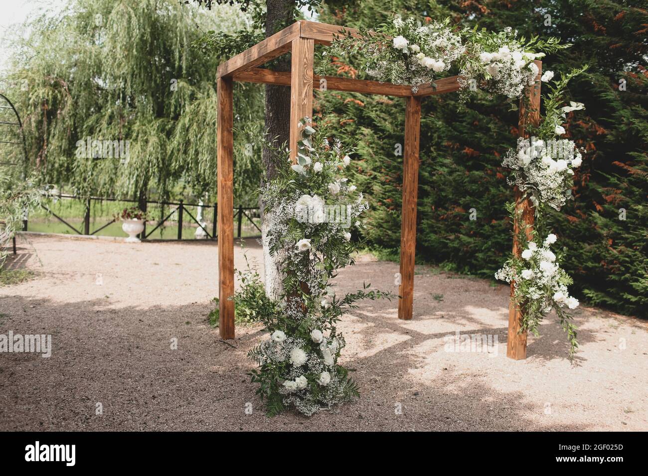 Rustic wedding arch for an ceremony decorated with white and flowers ...