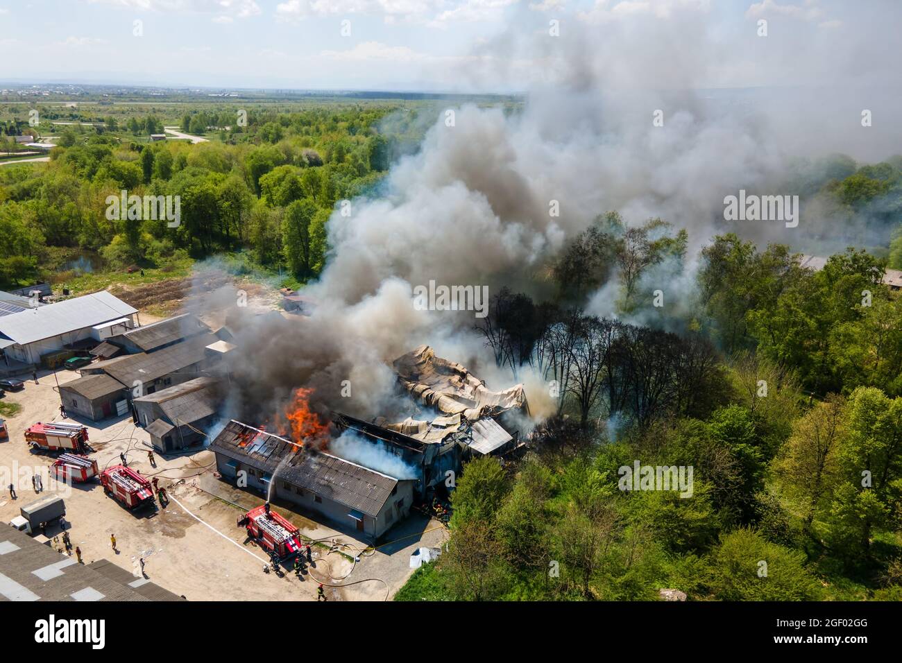 Aerial view of firefighters extinguishing ruined building on fire with ...