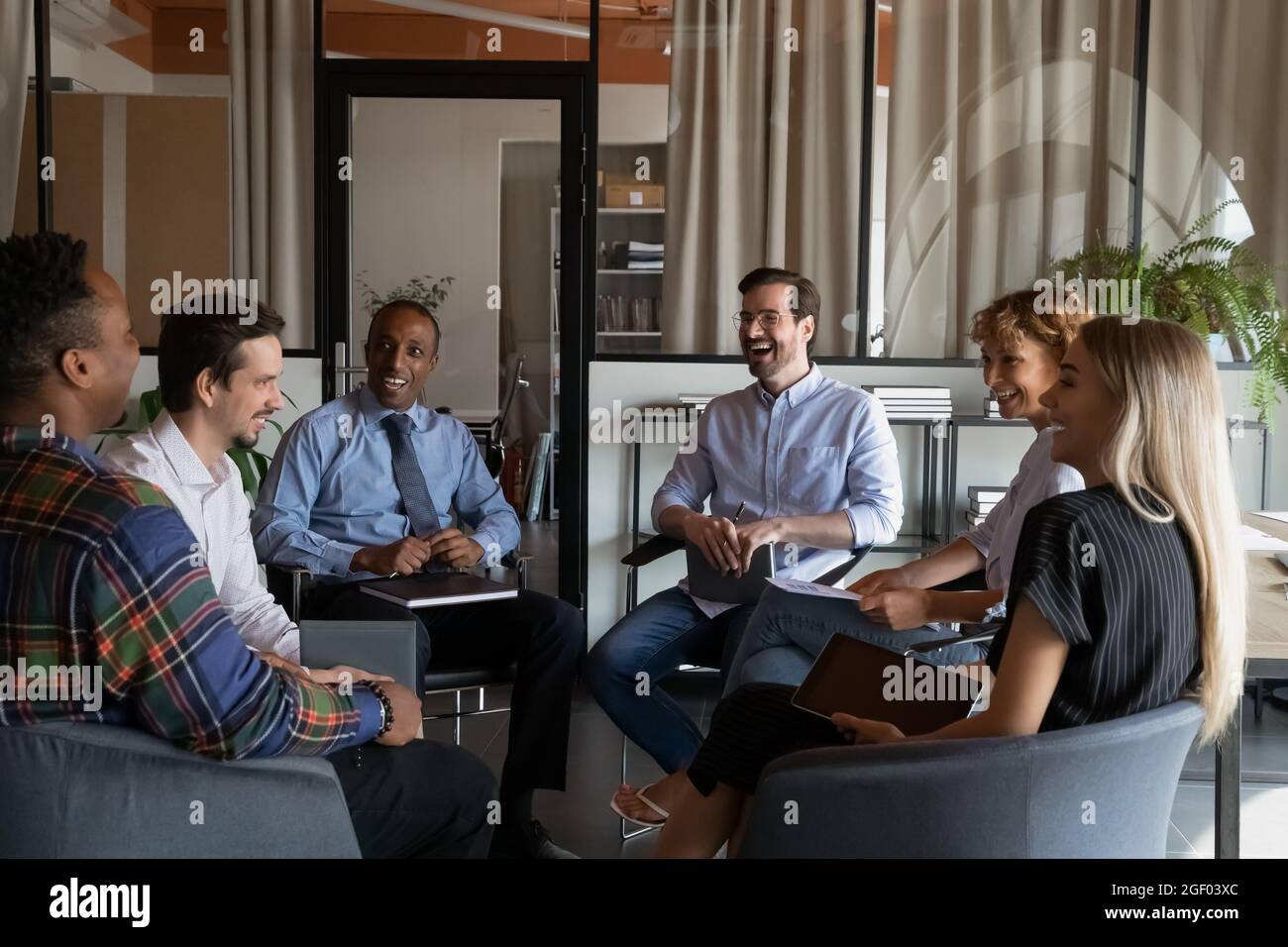 Smiling diverse employees laugh at team office meeting Stock Photo - Alamy