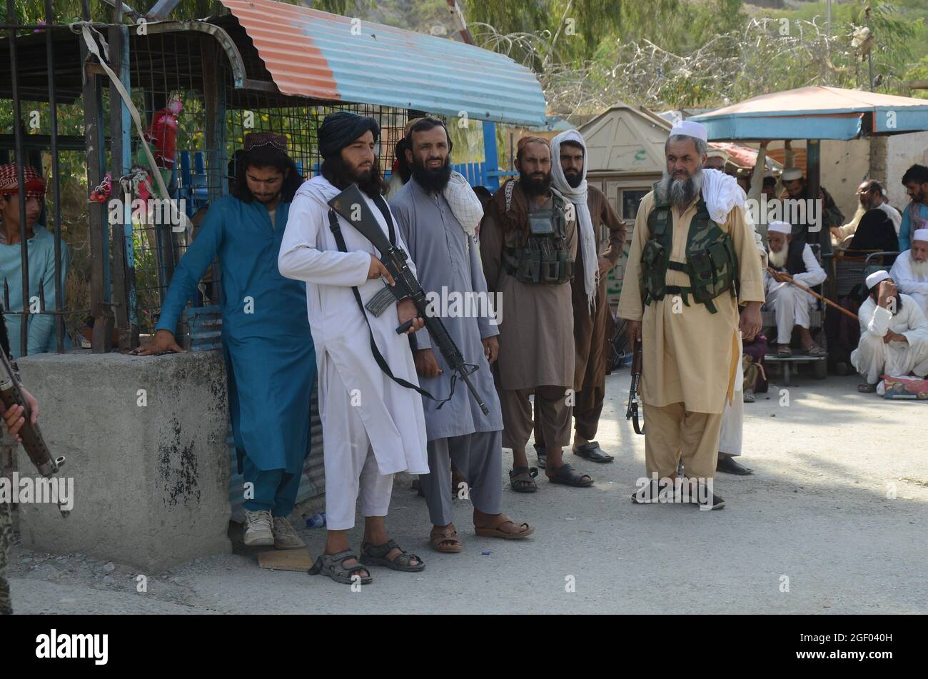 Taliban fighters stand guard on their side at a border crossing point ...