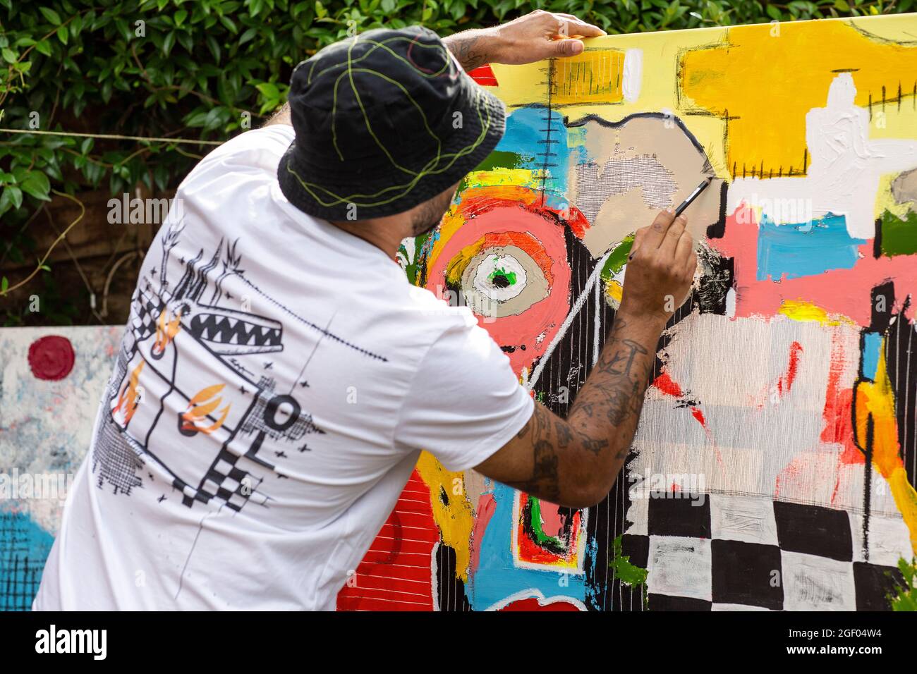 Back view of a male artist finishing his painting on canvas standing in ...