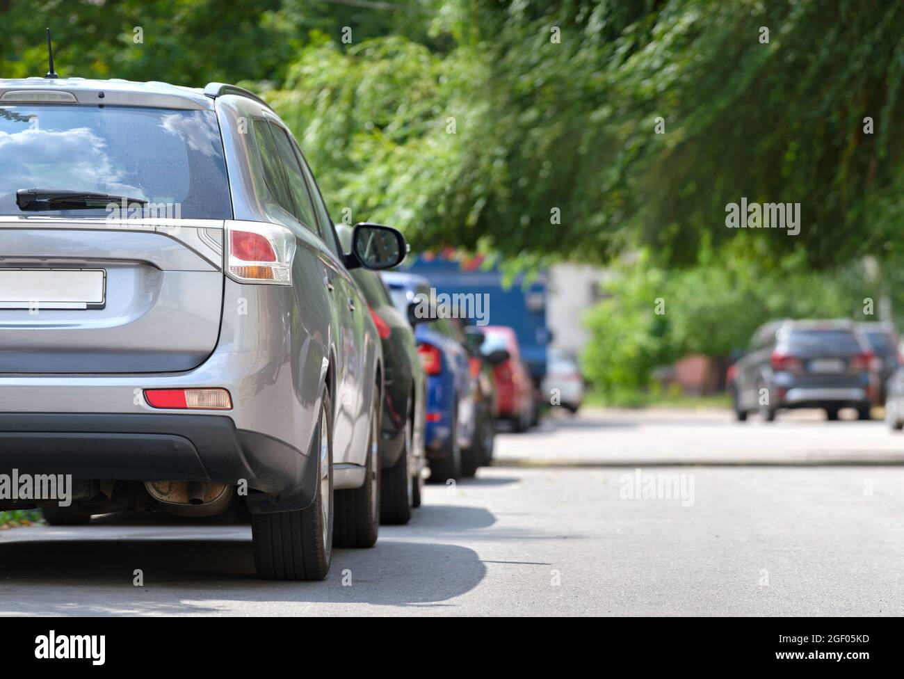 City traffic with cars parked in line on street side. Vehicle parking ...