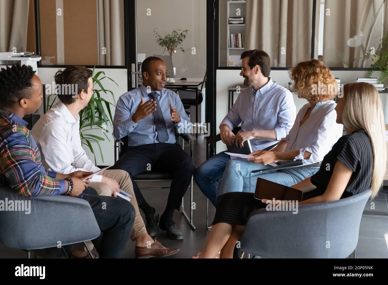 Multiethnic employees discuss ideas at team meeting Stock Photo - Alamy