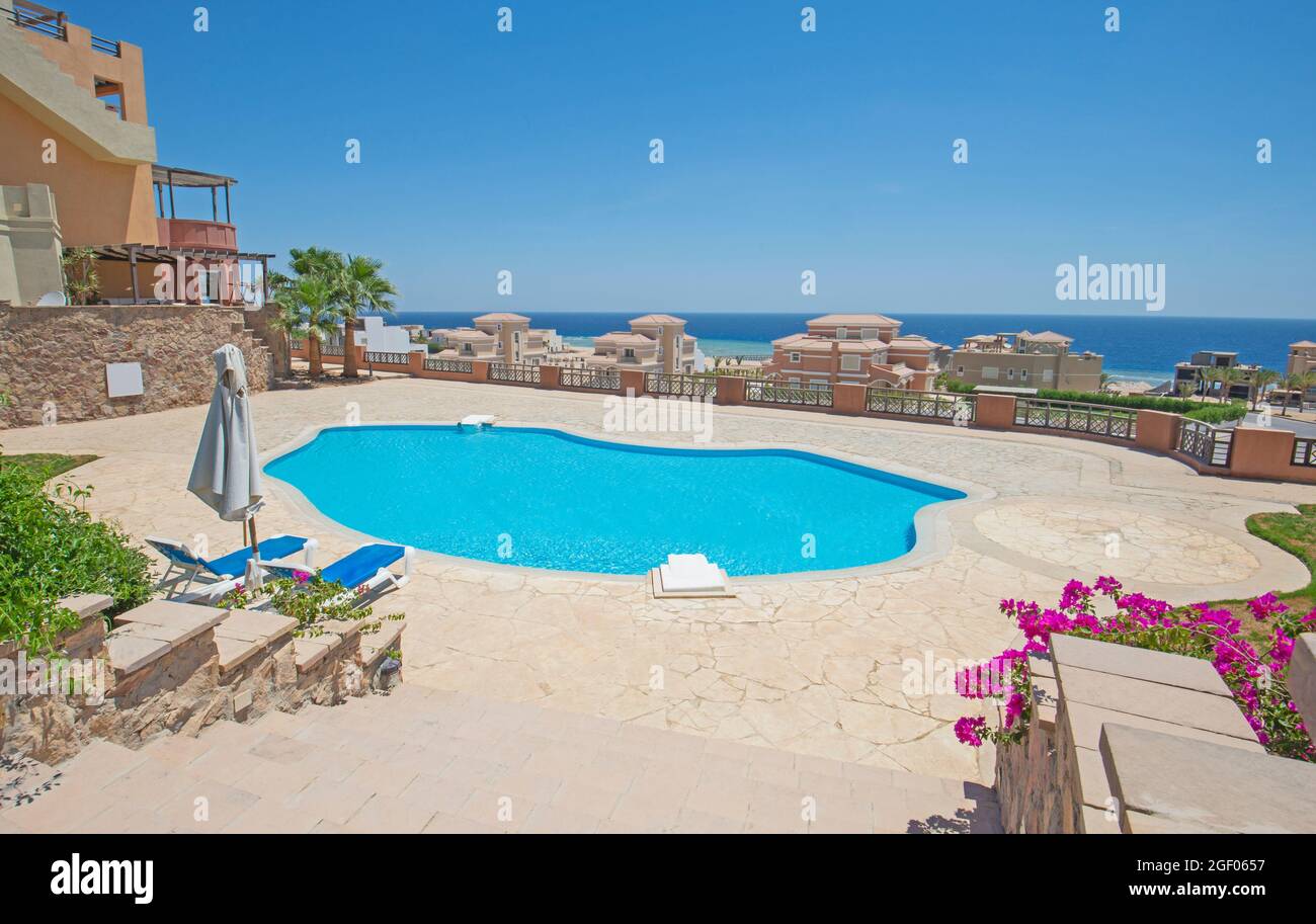 Large outdoor swimming pool at a luxury tropical hotel resort with sun ...