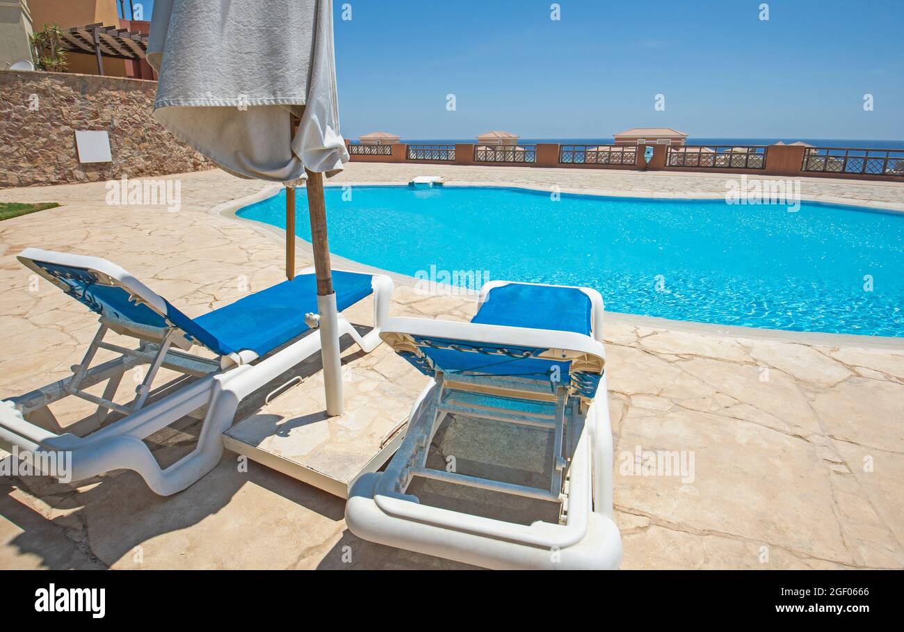Large outdoor swimming pool at a luxury tropical hotel resort with sun ...