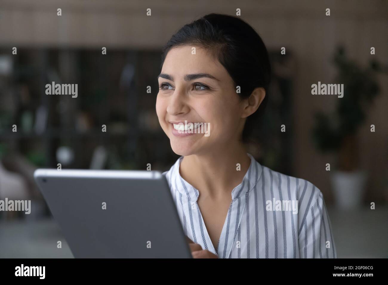 Smiling Indian woman use tablet make plans Stock Photo - Alamy