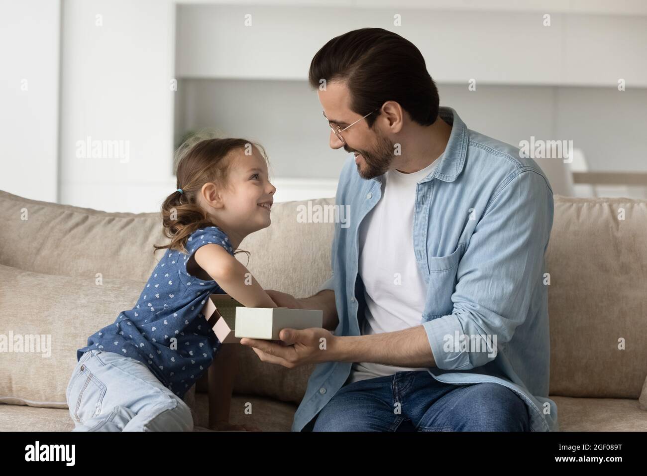 Happy dad giving gift to excited little daughter kid Stock Photo - Alamy