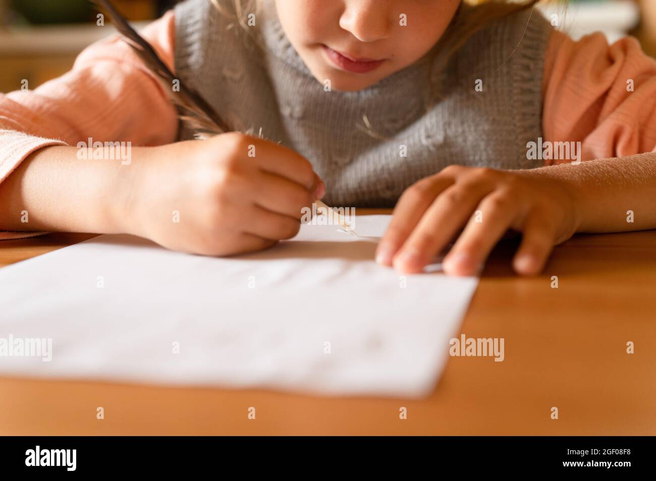 little seven year old kid girl draws a disappearing drawing on a paper ...