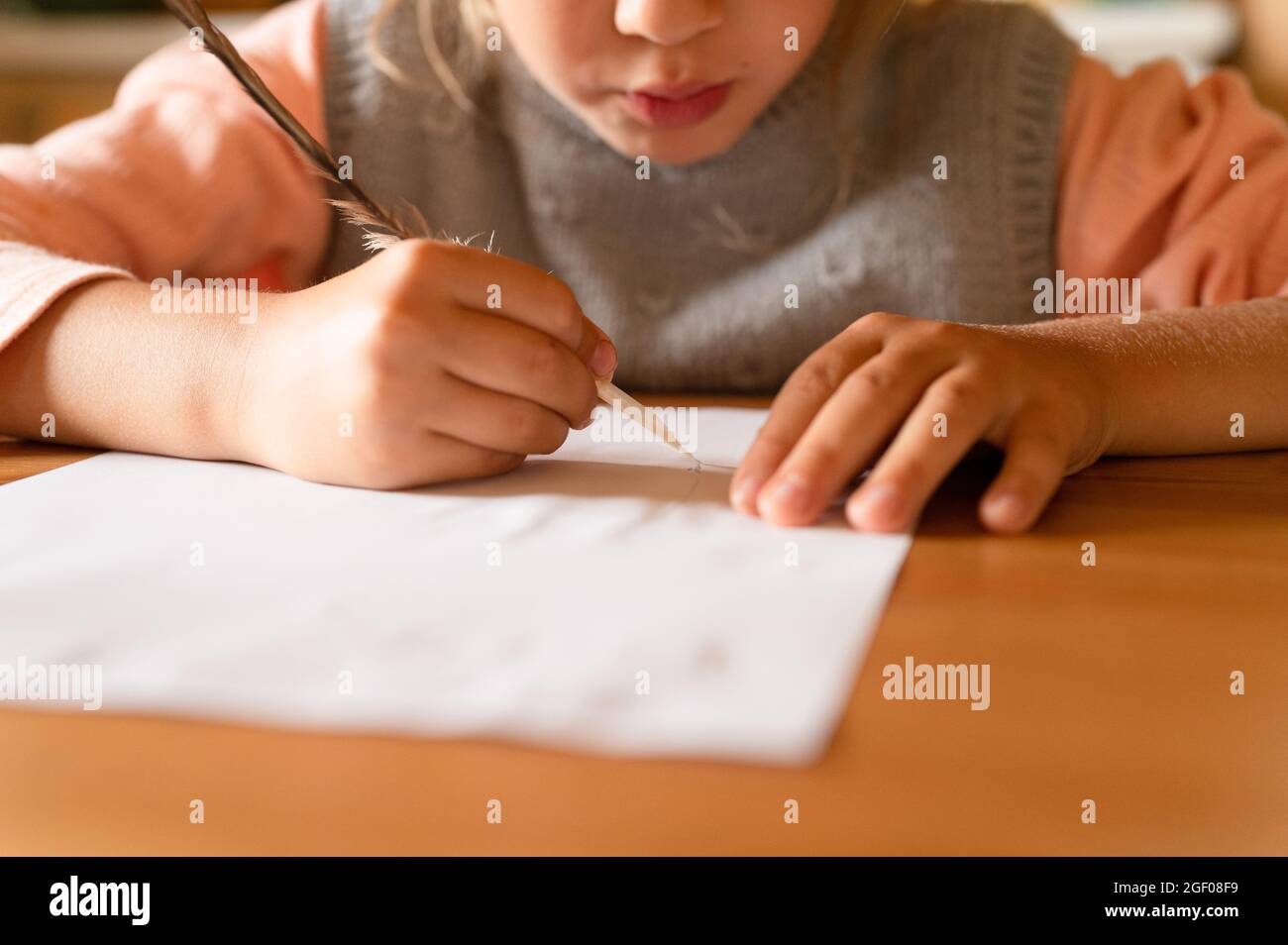 little seven year old kid girl draws a disappearing drawing on a paper ...