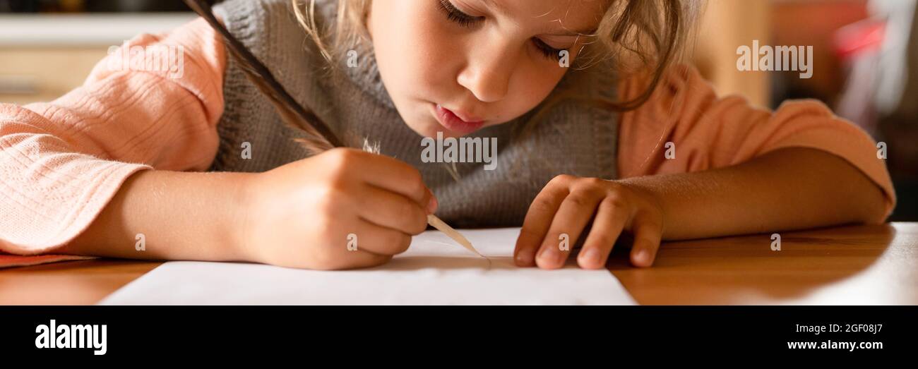 little seven year old kid girl draws a disappearing drawing on a paper ...