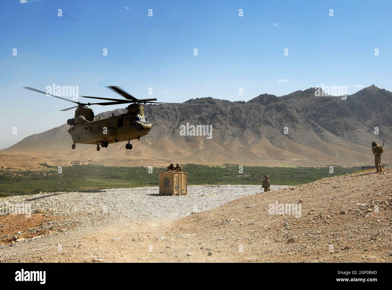 A CH-47 Chinook is guided toward a container for sling load in Chorah ...