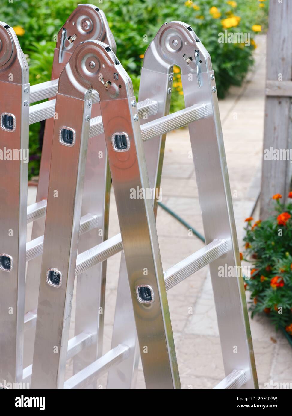 New aluminium multipurpose hinged ladder standing outdoors. Close-up ...