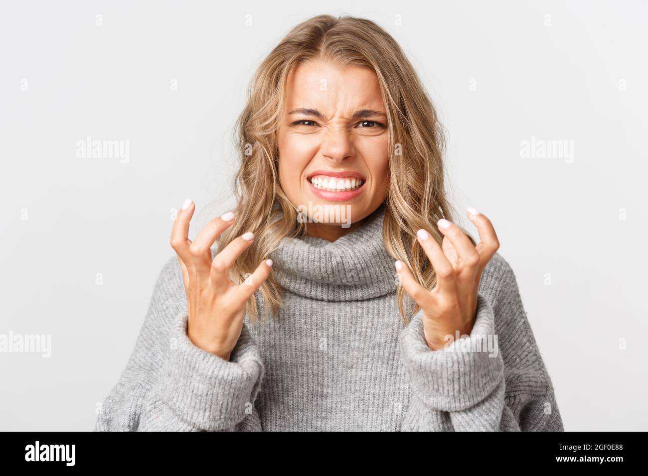 Image of angry blond girl in grey sweater, looking annoyed and mad ...