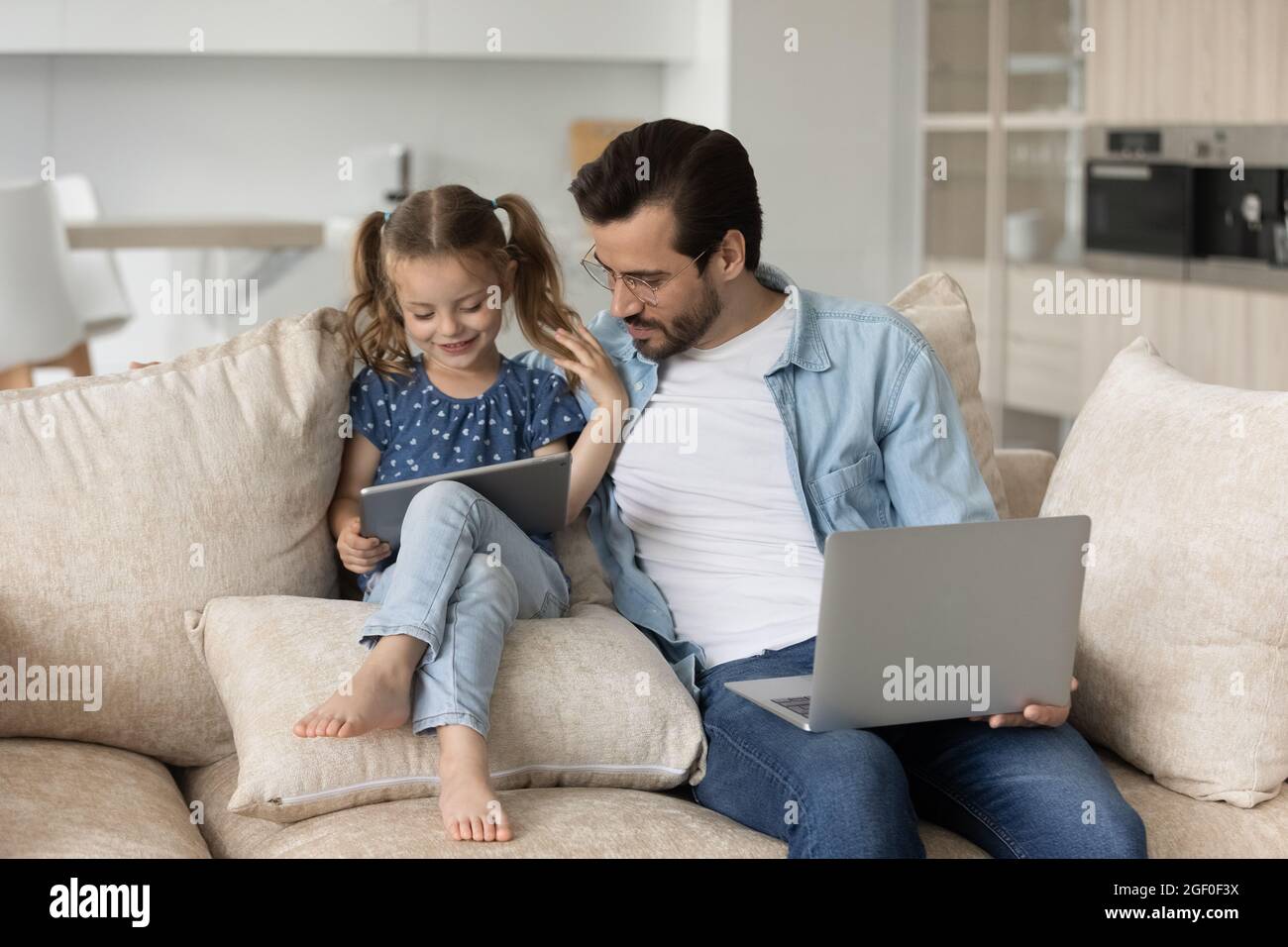 Happy gen Z kid and daddy using tablet and laptop Stock Photo - Alamy