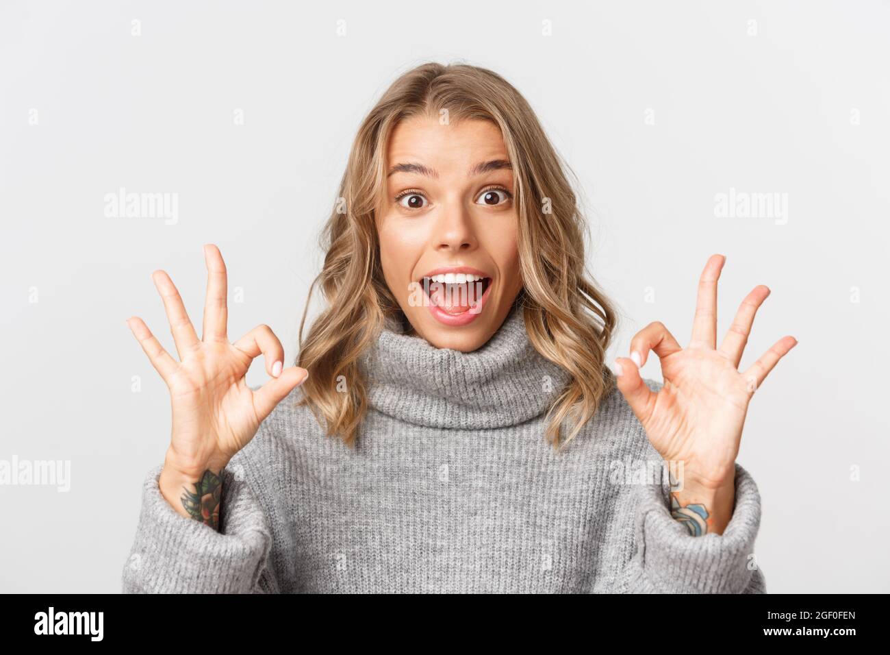 Close-up of attractive blond girl, showing okay signs and smiling ...