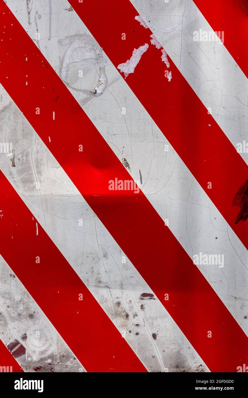 faded red and white diagonal stipes on flat steel sheet - caution road ...